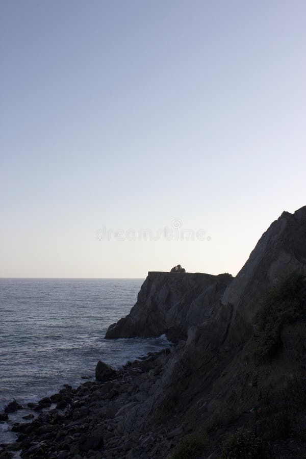 Ocean Water with Rock Cliffs Sillouhette during Sunset Stock Photo ...