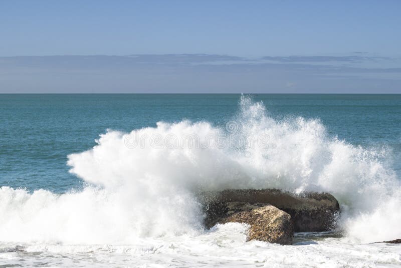 Ocean Wave Breaking in Splash Over Rock on the Beach Stock Photo ...