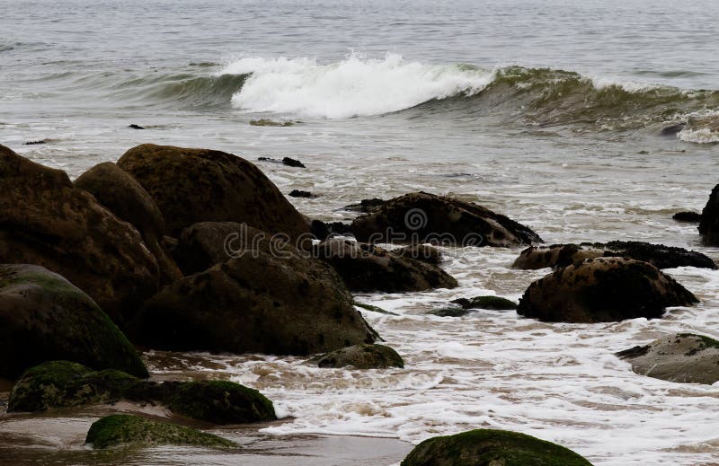 Ocean Wave with Rock Shore and Sand Beach Overcast Day Stock Image ...