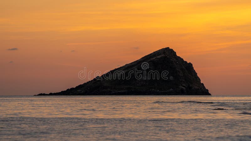 Ocean Waves Approaching a Big Stone by the Shore Captured at Sunset ...