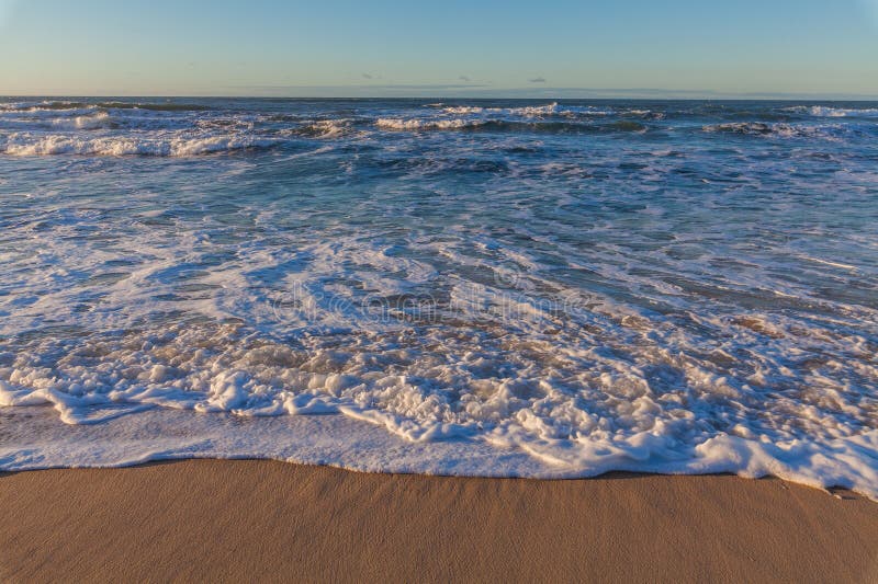 Ocean Waves Wash Onto a Sandy Beach, Creating Sea Foam and Patterns in ...