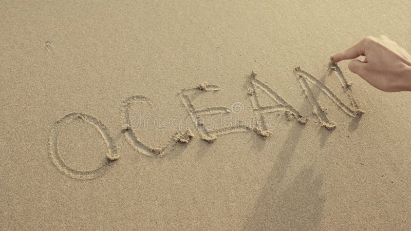 OCEAN Written on the Beach Sand Washed Aways by Waves. Stock Image ...
