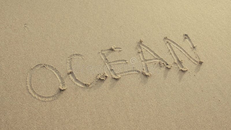 OCEAN Written on the Beach Sand Washed Aways by Waves. Stock Photo ...