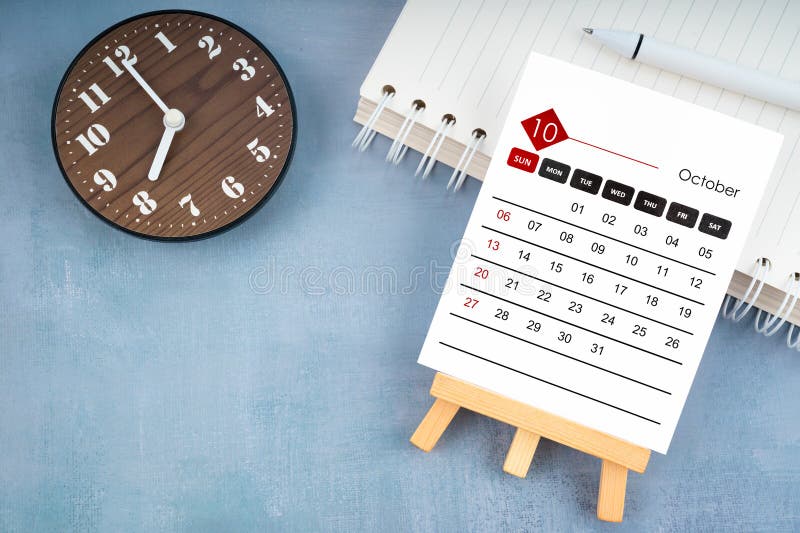 2024 October Calendar Page and Wooden Clock on Blue Wooden Stock Photo ...