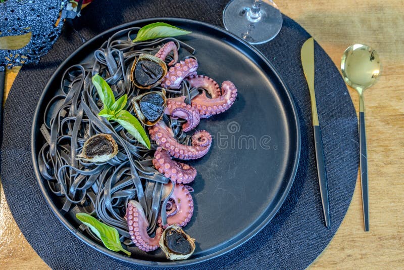 Octopus on a Bed of Black Squid Ink Pasta with Black Garlic on a Black ...