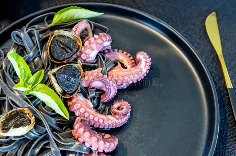 Octopus on a Bed of Black Squid Ink Pasta with Black Garlic on a Black ...