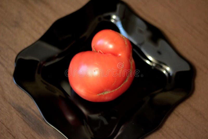 Red Tomato with an Unusual Shape on a Plate Stock Photo - Image of ...