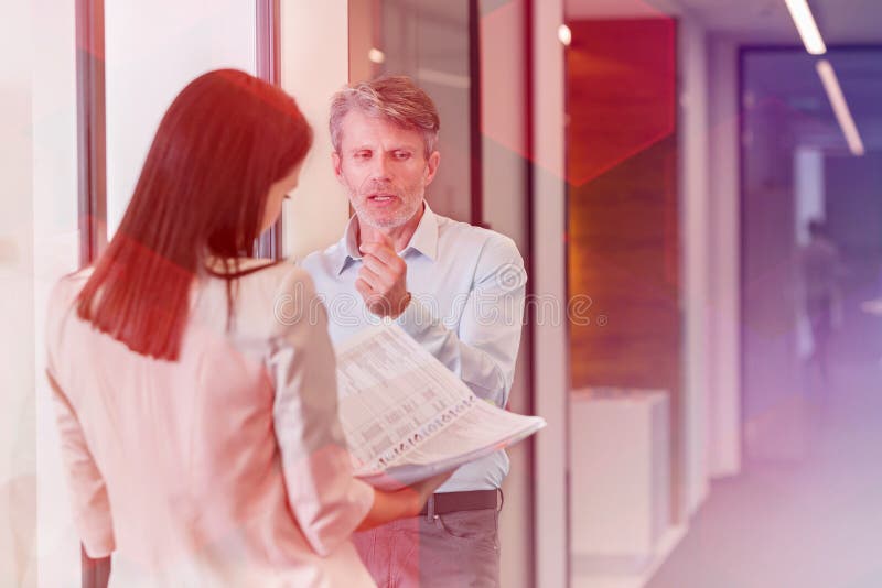 Business People Discussing Over File at Office Corridor Stock Image ...