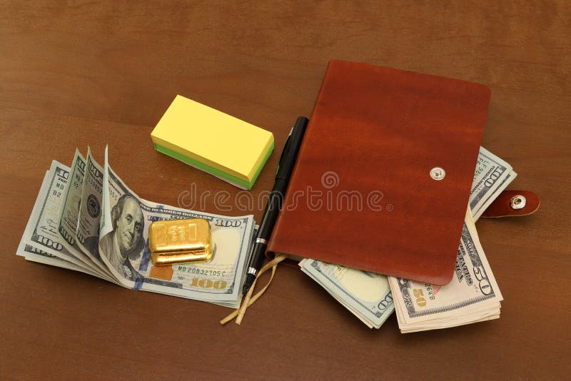 On the Office Desk are Cash Dollars, Gold Bars. Notepad for Notes and ...