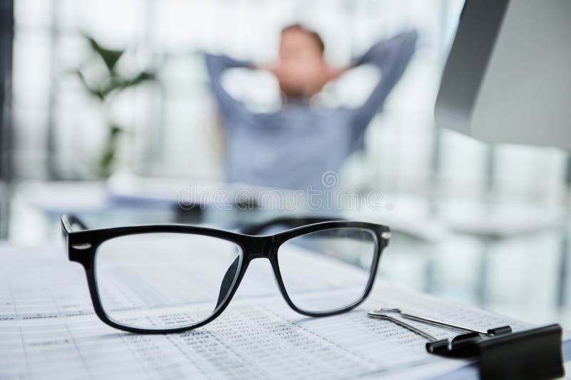 Office Desk with Glasses and a Financial Report on the Background of a ...