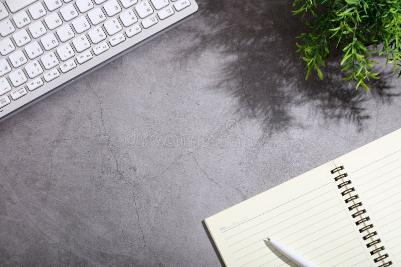 An Office Desk with a Computer Keyboard and a Notebook with a Pen on ...