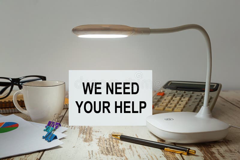 Desktop with a Lamp that Illuminates the Inscription we NEED YOUR HELP ...