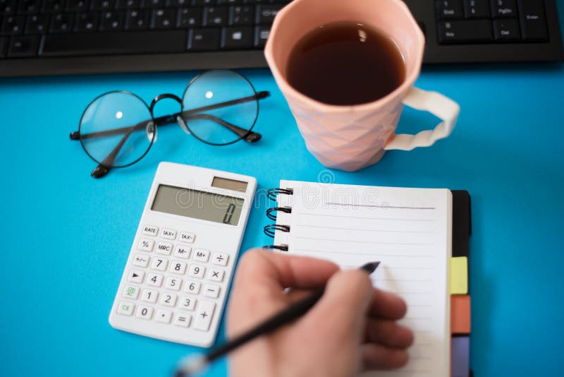 Office Desk with Other Supplies and Male Hand Writing in Notepad. Stock ...