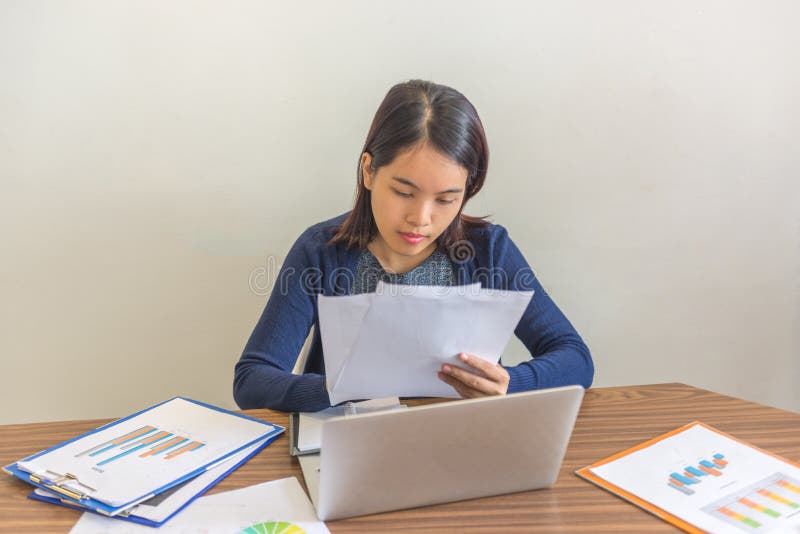 Office Employee Reading Sales Report and Writing Notes Stock Photo ...
