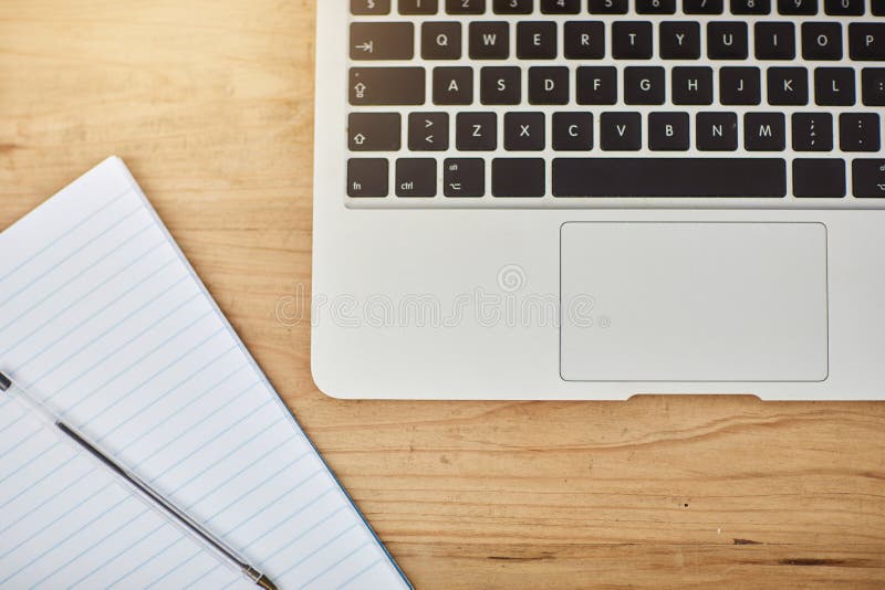Office Essentials. High Angle Shot of a Laptop and Notebook on a Desk ...