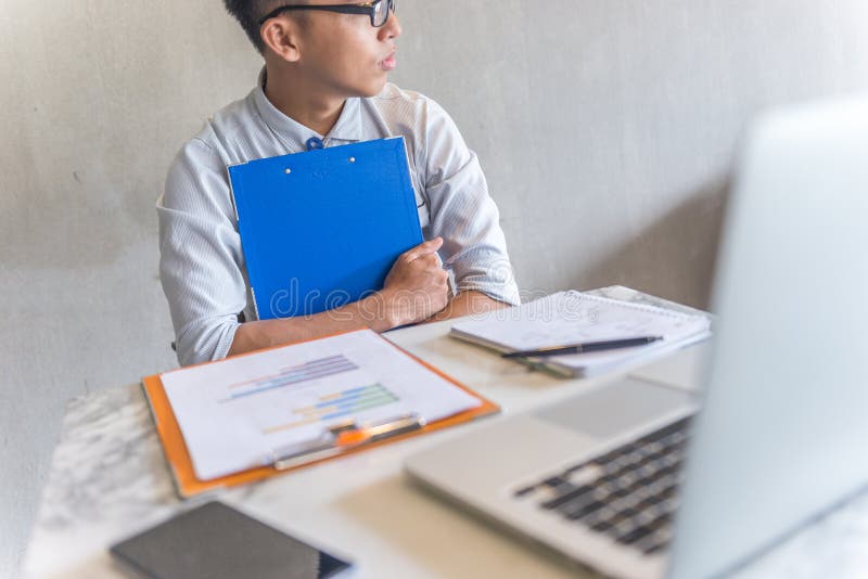 Office Man Sitting at Work Place Holding Folder and Thinking Stock ...