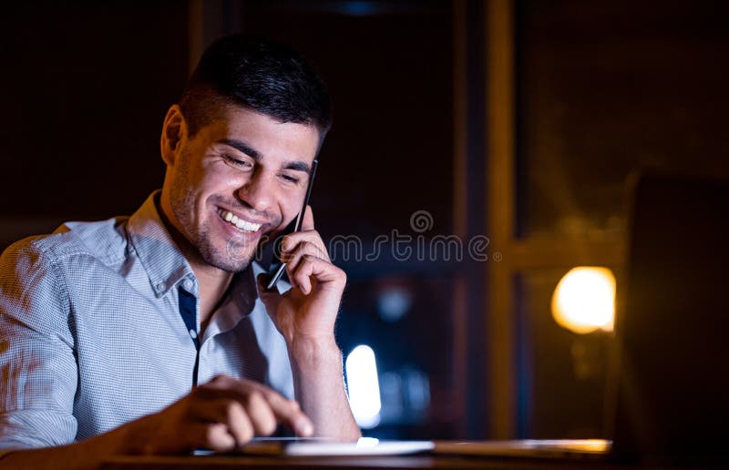 Office Manager Talking on Cellphone Using Tablet Overnight at Workplace ...