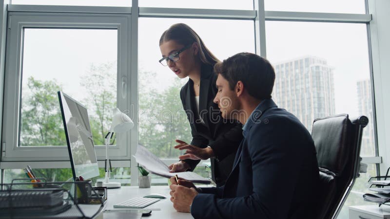 Office Managers Discussing Papers Looking Computer. Workers Discussing ...