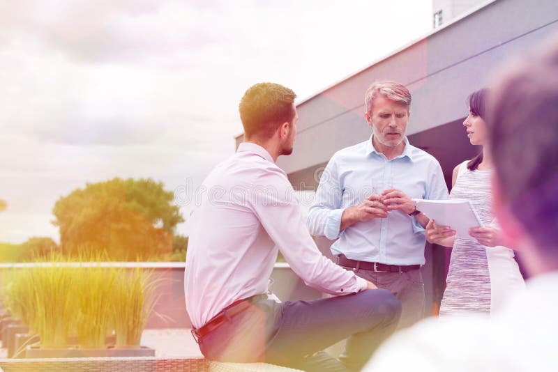 Professionals Discussing Over Documents with Colleagues at Office ...