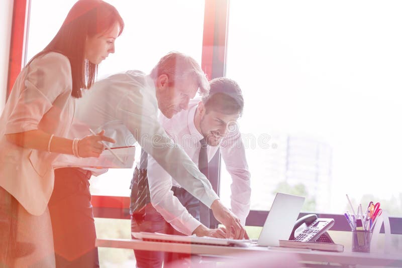 Professionals Looking at Laptop Seen through Window in Office Stock ...