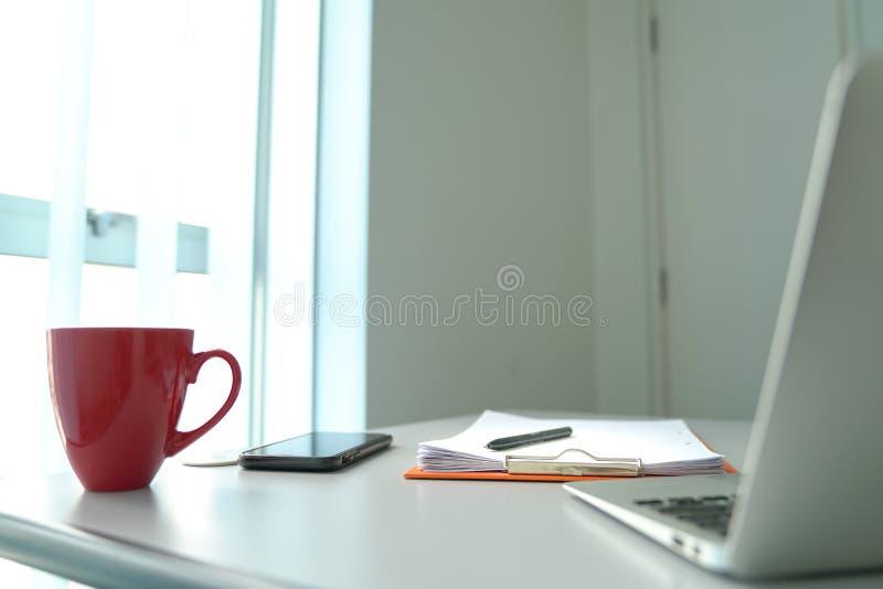 Office Table Next To Windows. Computer, Cell Phone, Coffee Cup and ...