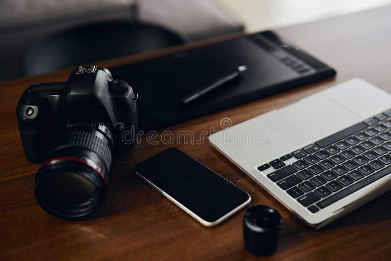 An Office Table on Which There is a Camera, Phone, Laptop and Graphic ...