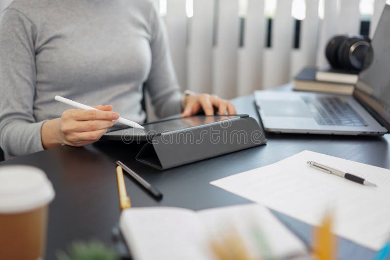 Office Work Concept a Female Officer Using Her Tablet To Work on a ...