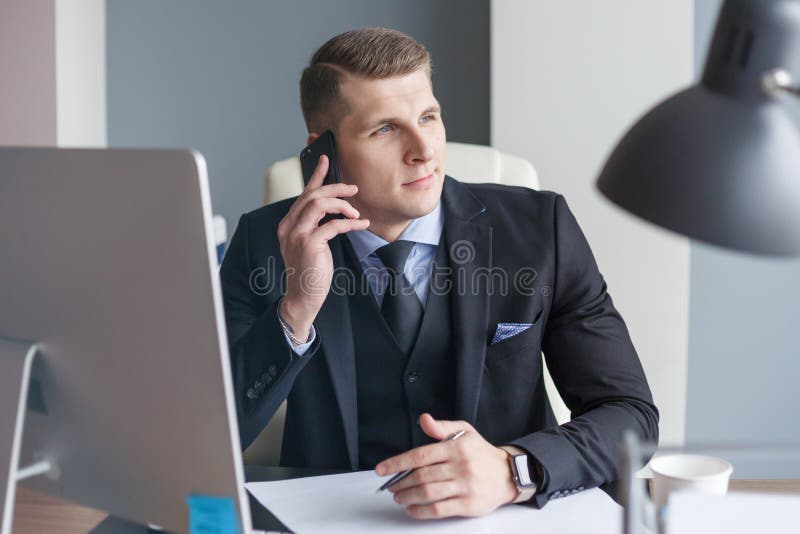Office Worker Calling on Mobile Phone, Sitting at Desk Stock Image ...