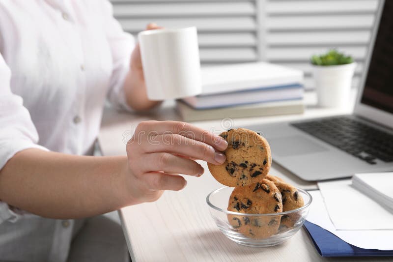 Office Worker with Cup of Drink Taking Chocolate Chip Cookie from Bowl ...