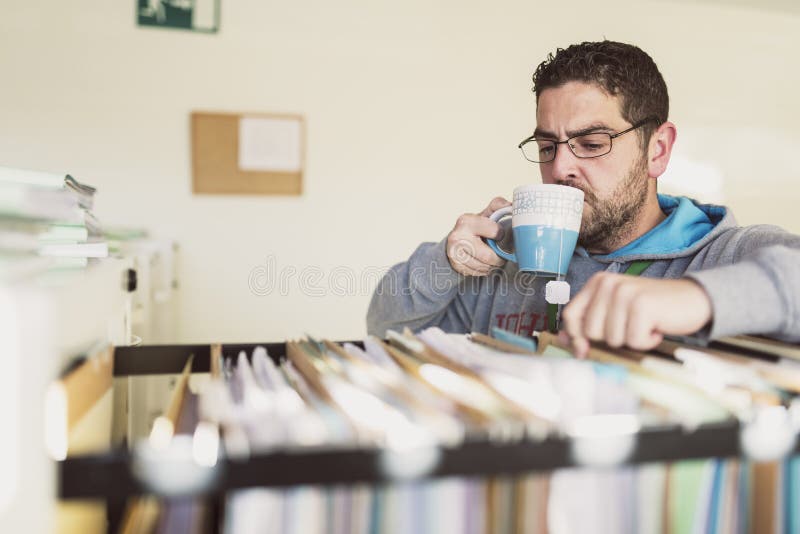 Office Worker Drinking Tea while Looking Files at Work Stock Image ...