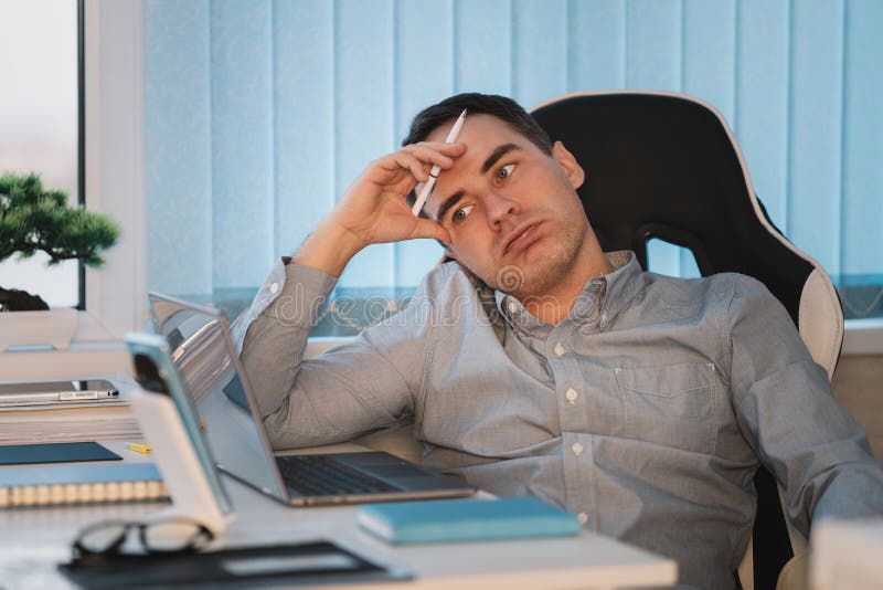Office Worker Experiencing Stress Holding Head with Hands while Looking ...