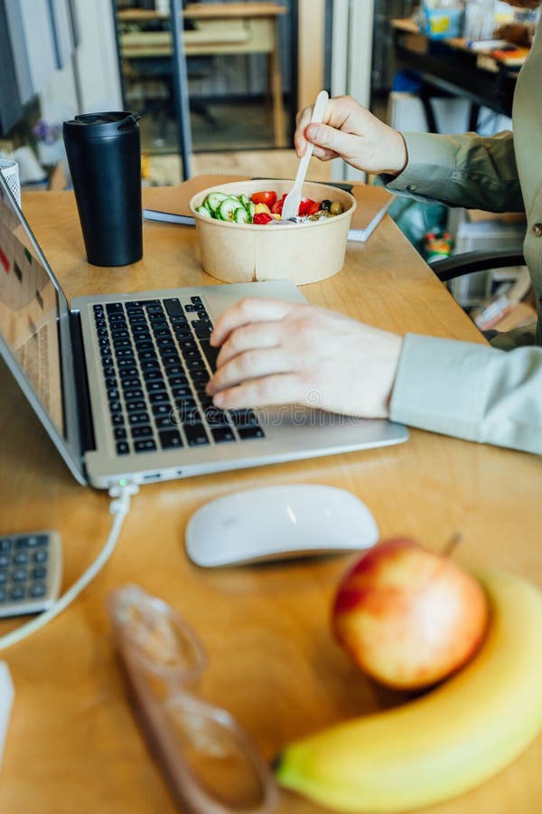Office Worker is Having a Healthy Salad while Using a Laptop Computer ...