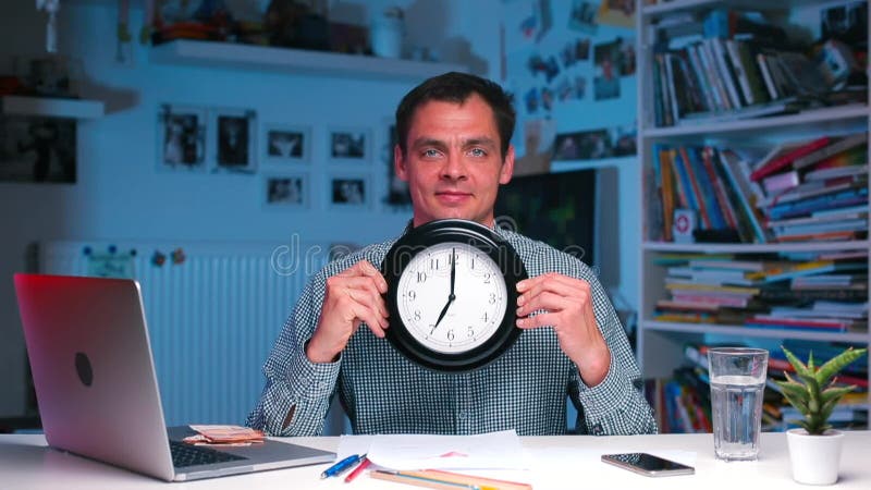 The Office Worker Holds the Clock in His Hands, on the Clock Time 07 00 ...