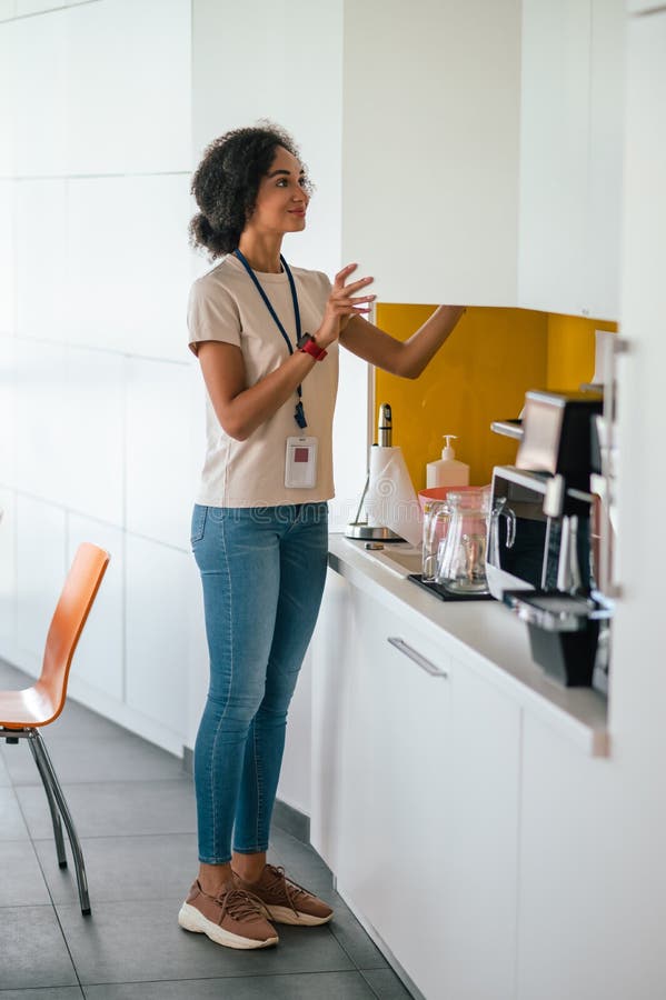 Office Worker in the Office Kitchen Taking Something from the Cupboard ...