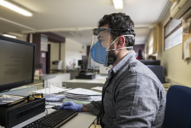 Office Worker with Plastic Protective Screen and Face Mask Working on ...