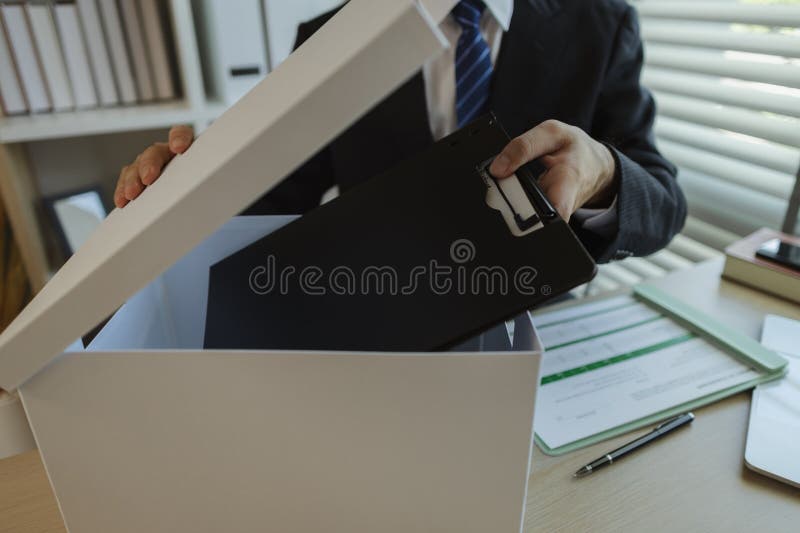 An Office Worker is Putting Important Documents in Boxes To Prevent ...