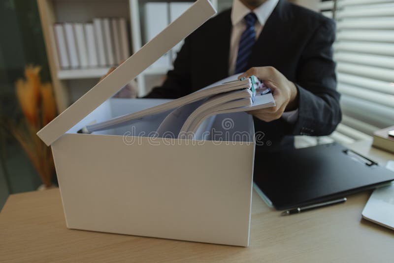 An Office Worker is Putting Important Documents in Boxes To Prevent ...