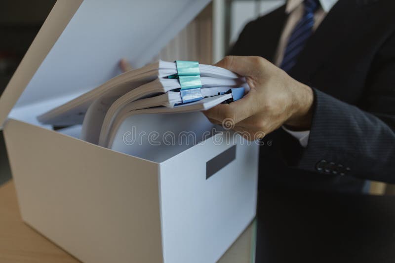 An Office Worker is Putting Important Documents in Boxes To Prevent ...