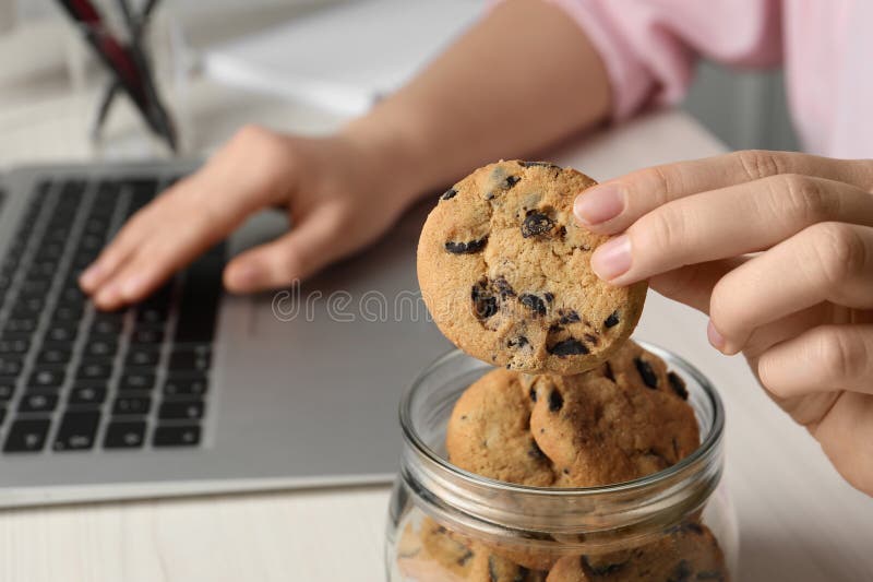 Office Worker Taking Chocolate Chip Cookie from Jar at Workplace ...
