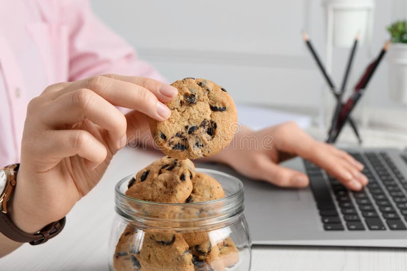 Office Worker Taking Chocolate Chip Cookie from Jar at Workplace ...