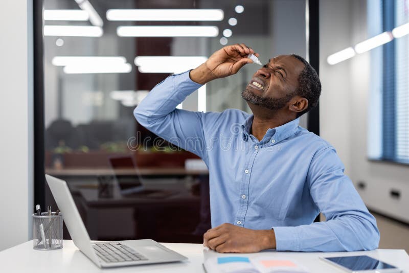 Office Worker Using Eye Drops at Desk in Modern Workplace, Looking for ...