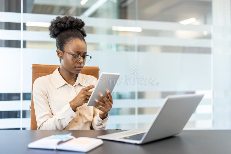Office Worker Using Tablet while Sitting at Desk with Laptop in Modern ...