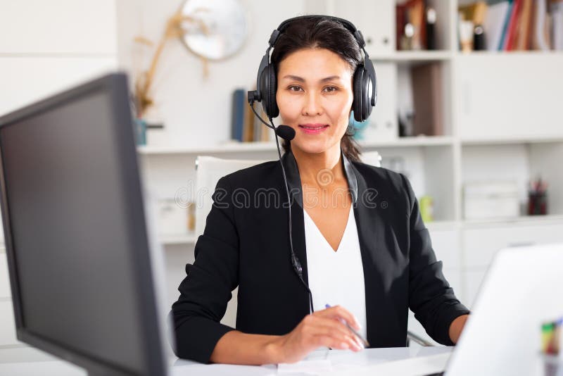 Office Worker Woman is Working at a Computer and Talking by Headset ...
