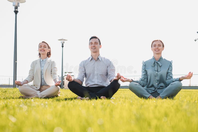 Office Workers Meditating Together Sitting on the Grass Stock Image ...