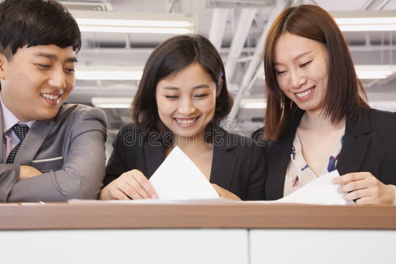 Office Workers Working Together, Looking at Documents Stock Image ...