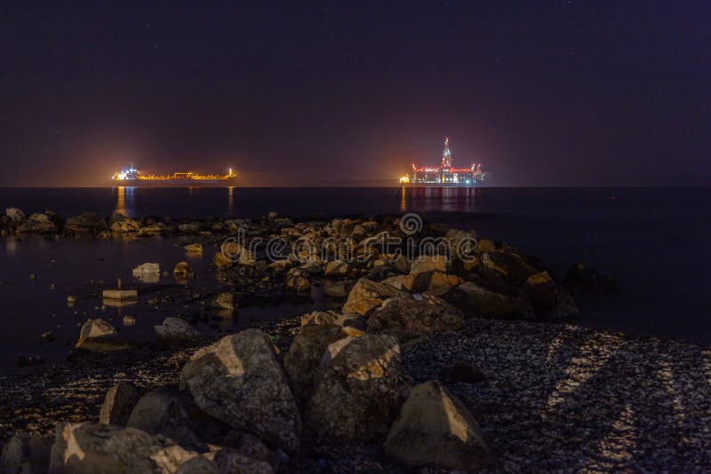Offshore Oil Platform at Night with Lights Reflected in the Water Stock ...