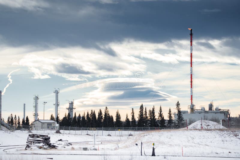 Oil and Gas Plant with a Flare Stack and Flame Under a Dramatic Winter ...