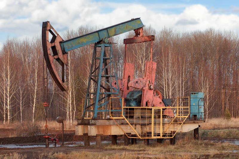 An Oil Pump Produces Crude Oil in the Middle of an Autumn Forest Stock ...