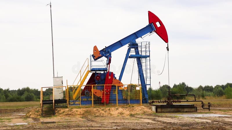 An Oil Pump Pumps Oil from a Drilled Well in an Oil Field Stock Video ...