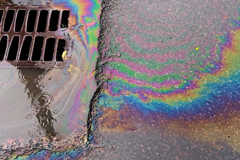 An Oil Slick Against the Backdrop of an Asphalt Road Flows into a Storm ...